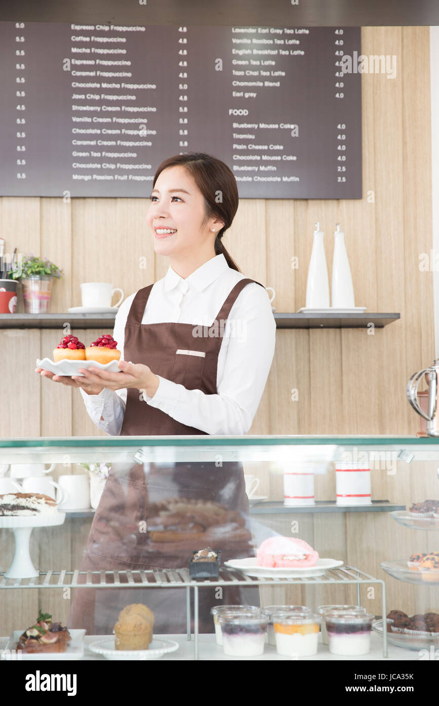 Smiling female worker at bakery Stock Photo - Alamy