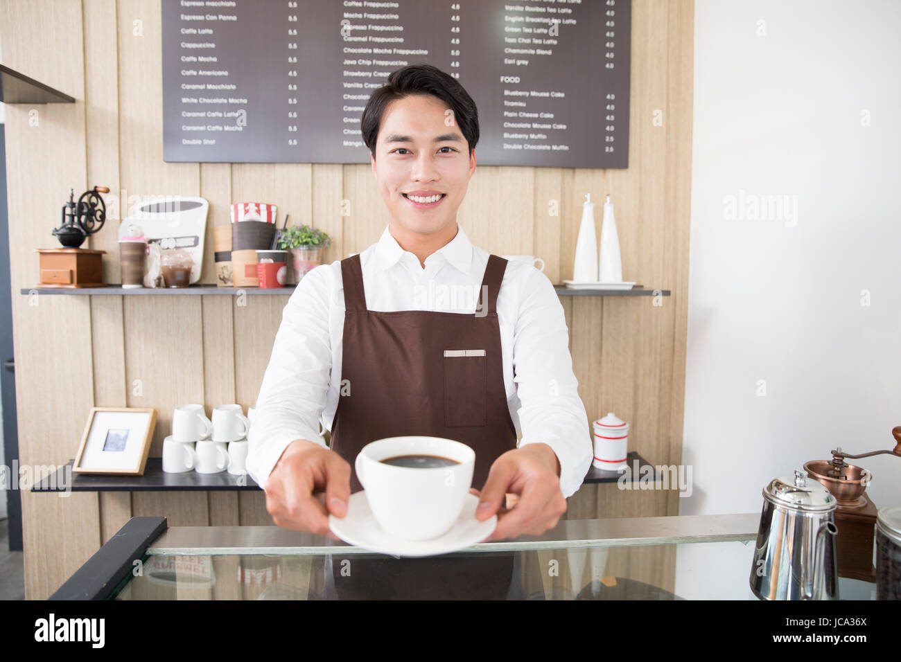 Portrait of young smiling worker at cafe Stock Photo - Alamy