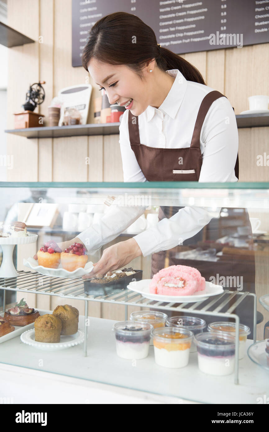Young smiling female worker at cafe Stock Photo - Alamy