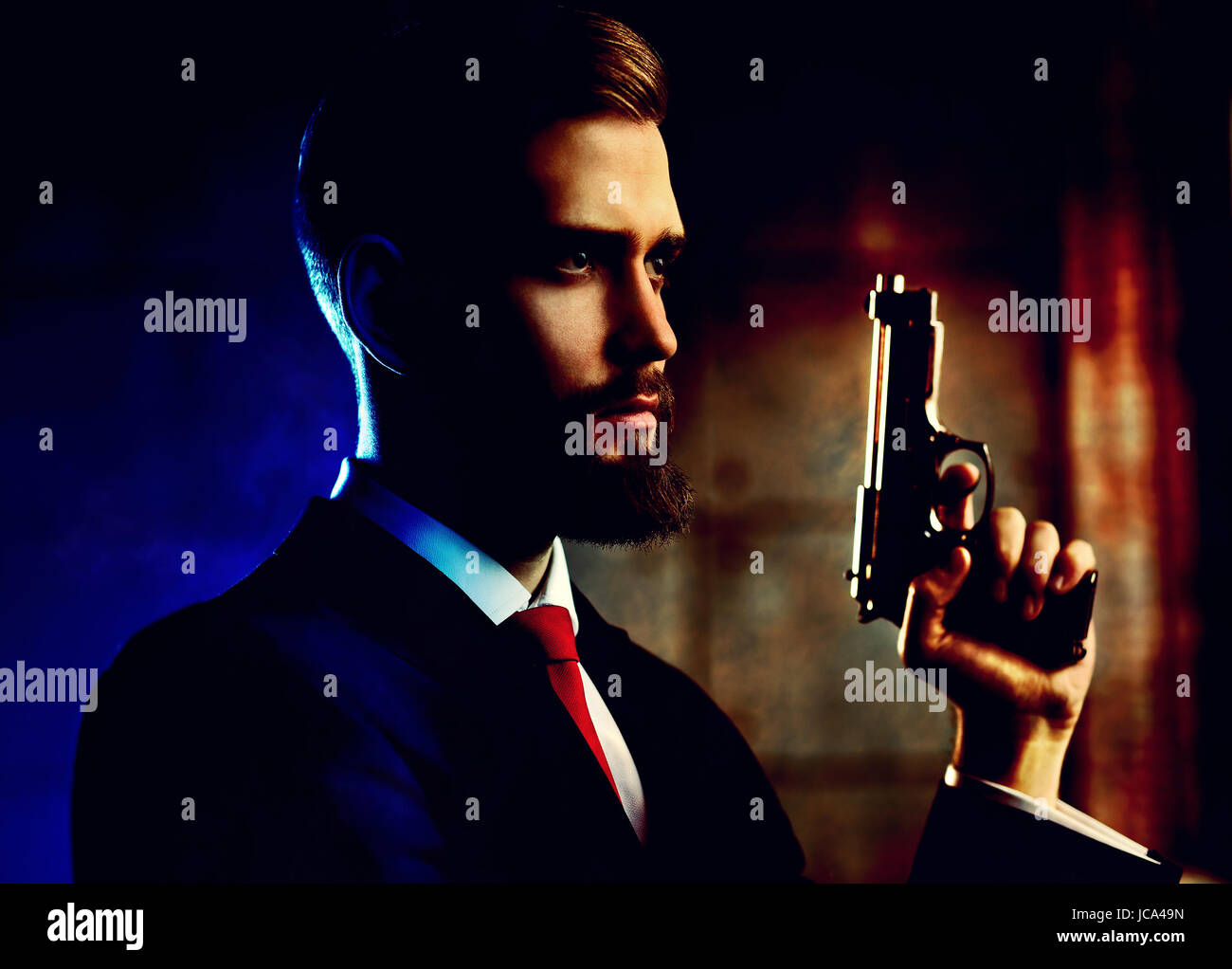 Young handsome man holding hand gun hi-res stock photography and images ...