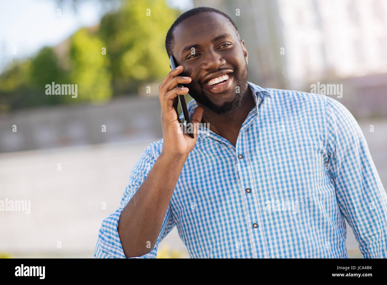 Sociable excited guy calling his friend Stock Photo - Alamy