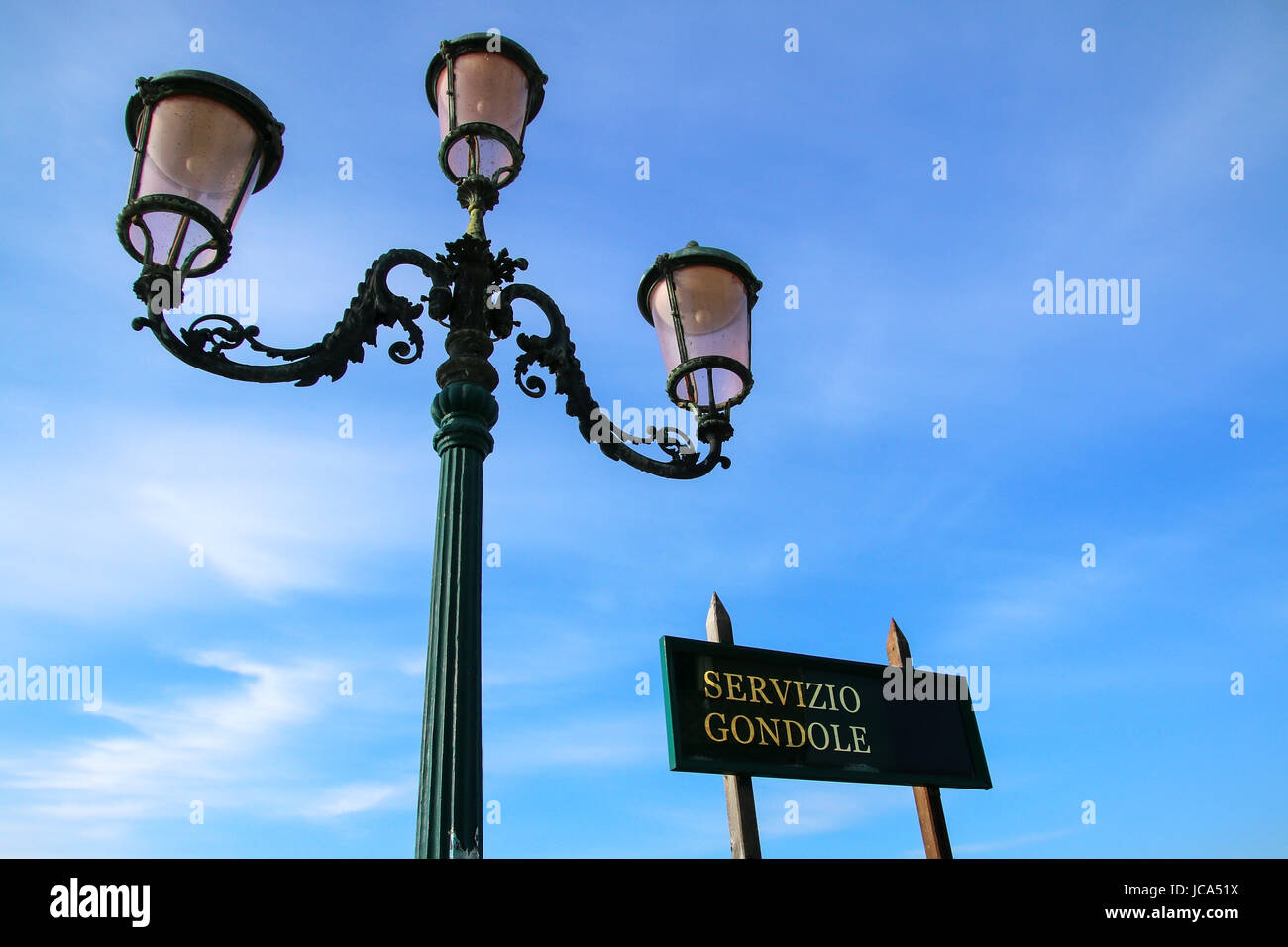 Gondola service sign and street lamp against blue sky near Piazza San ...