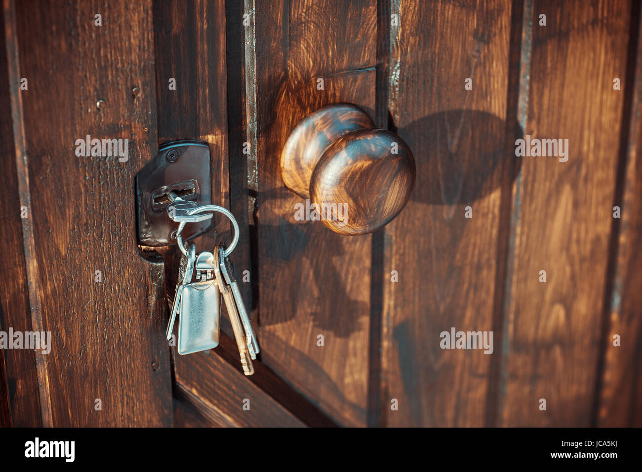 Handle and keys in lock of wooden door of fence Stock Photo - Alamy