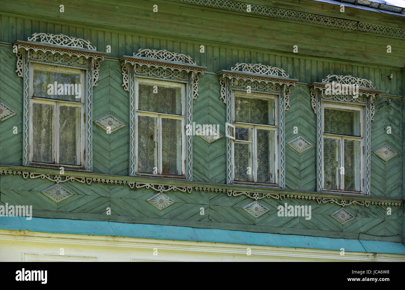Facade of the old russian wooden house with windows and carved frames ...