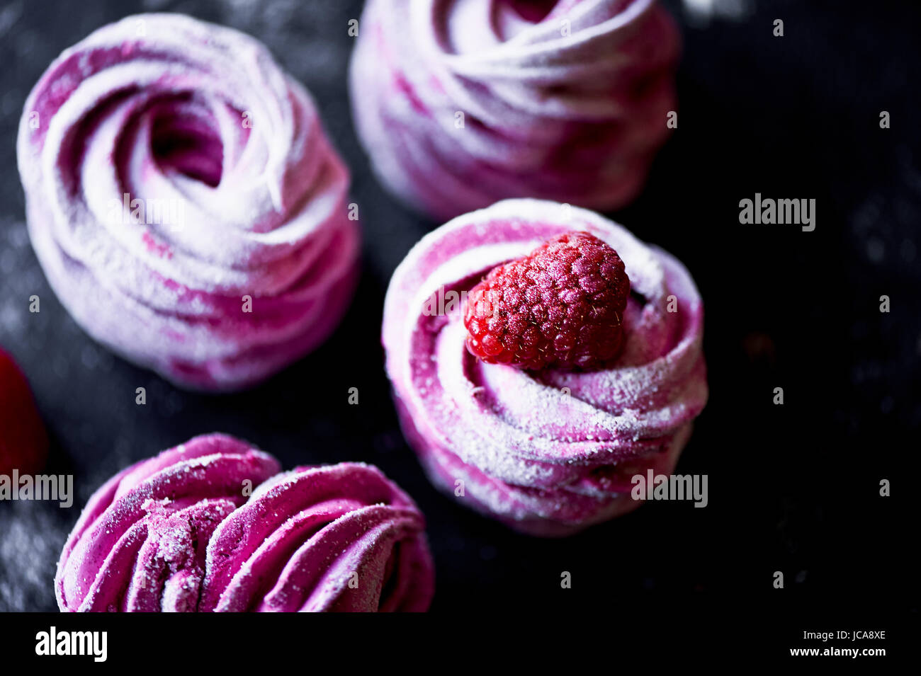 Many purple marshmallow on a dark surface. A contrasting picture. A ...