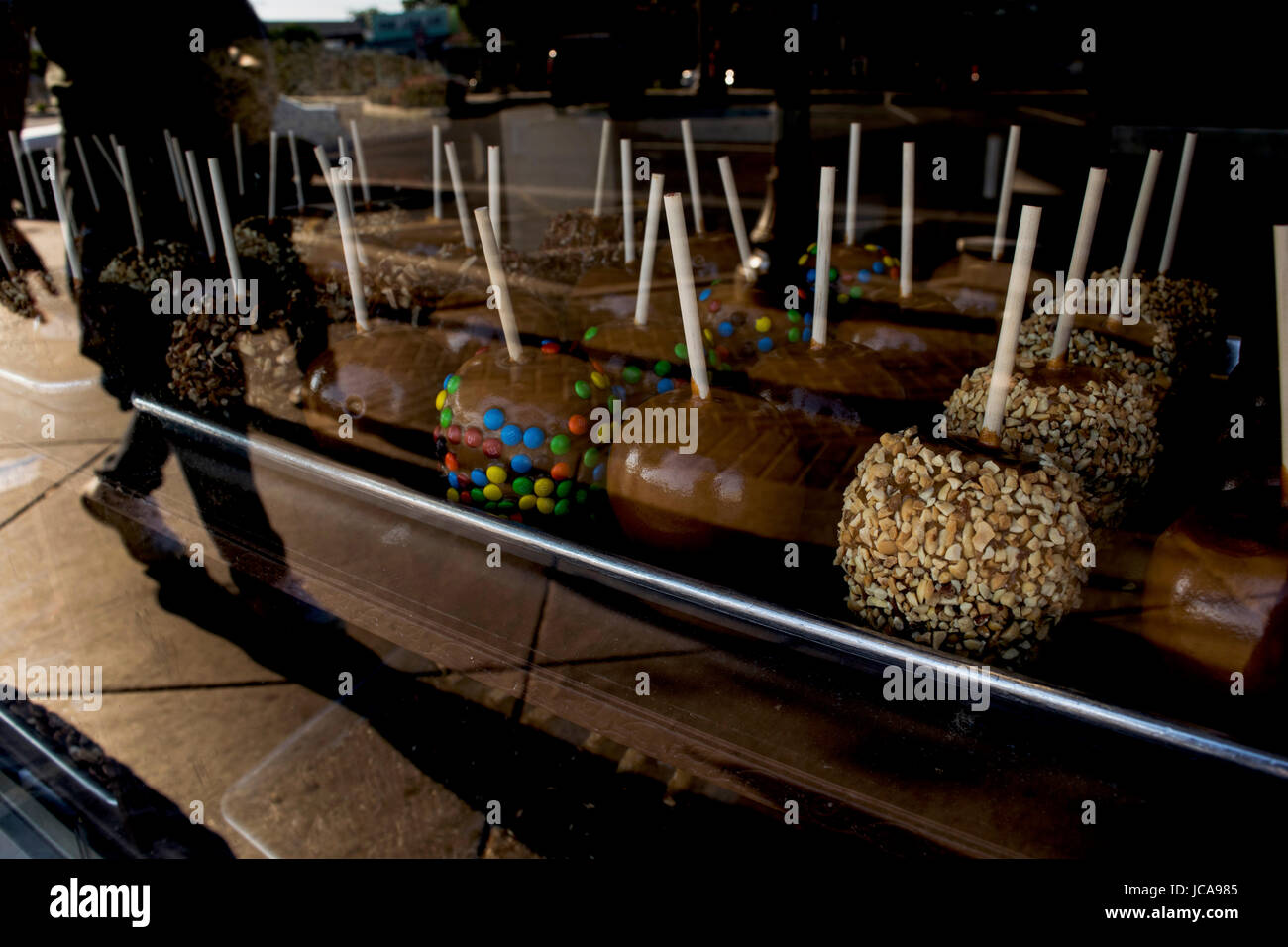 candy apples in candy story window with person walking by Stock Photo ...