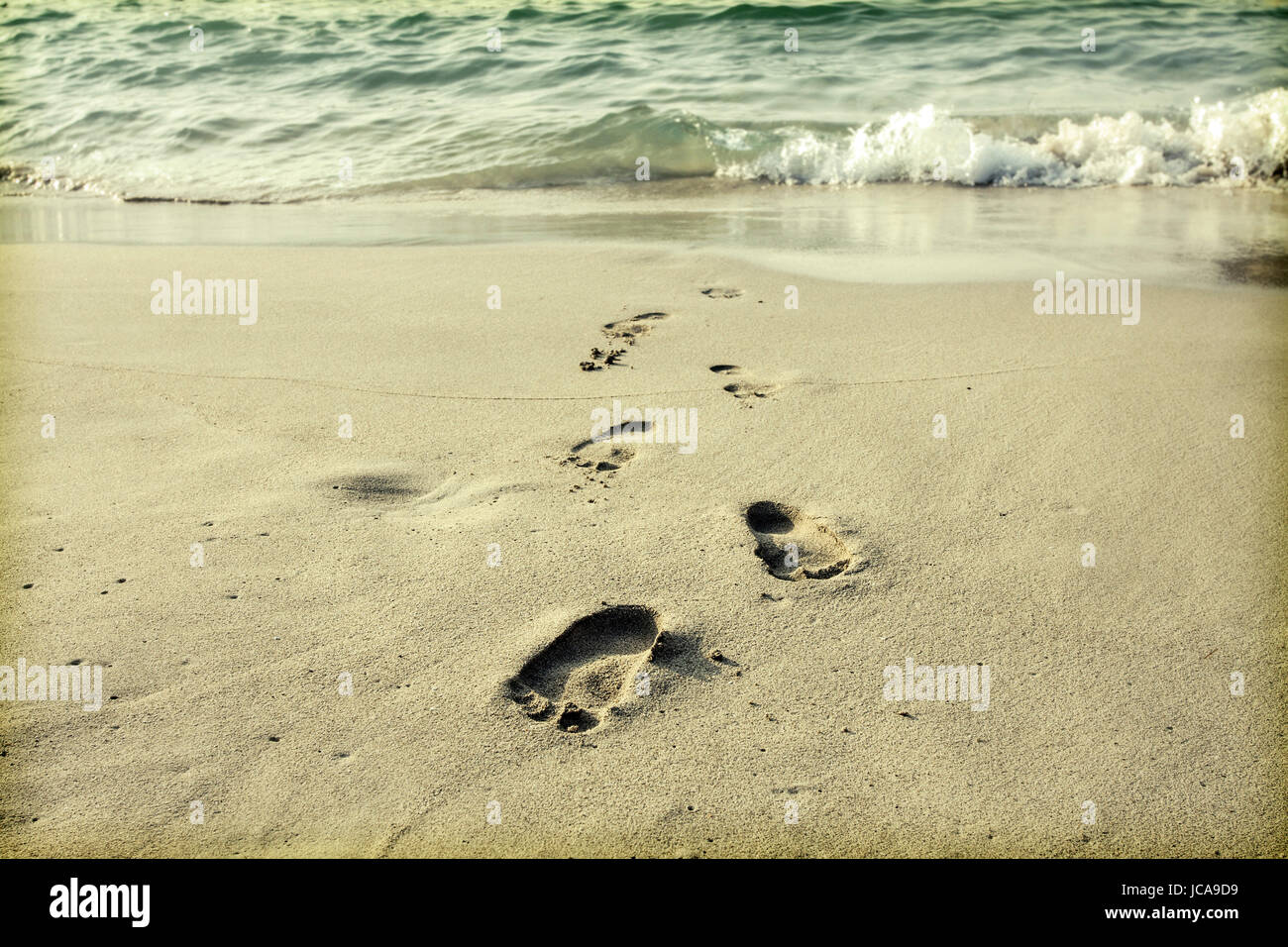 Footsteps in the sand on the beach Stock Photo - Alamy