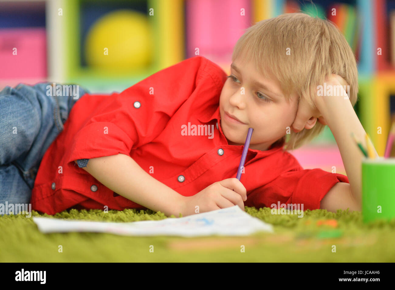 Portrait of a cute boy drawing with pencils Stock Photo - Alamy