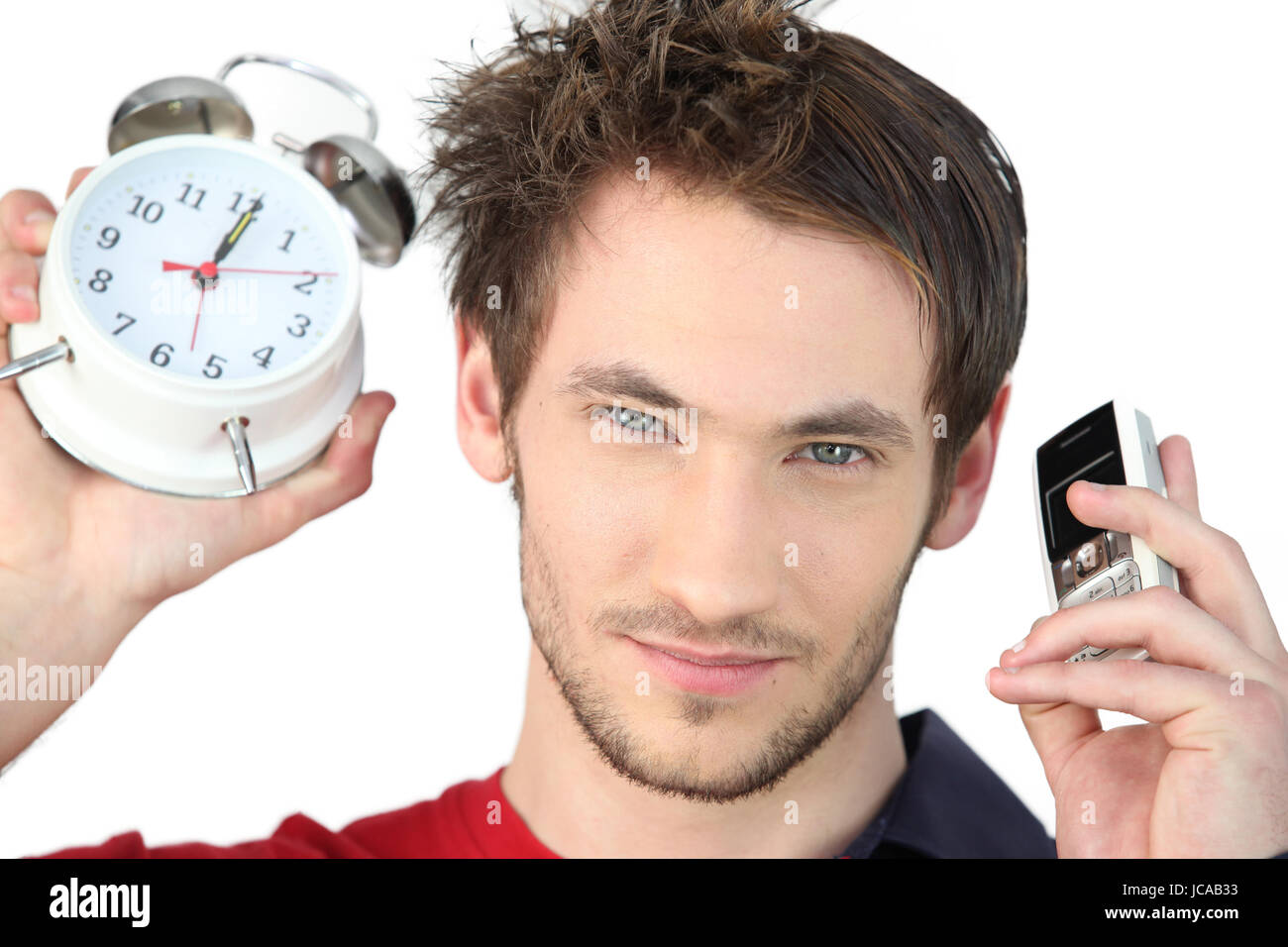 Man stood alarm clock and mobile Stock Photo - Alamy