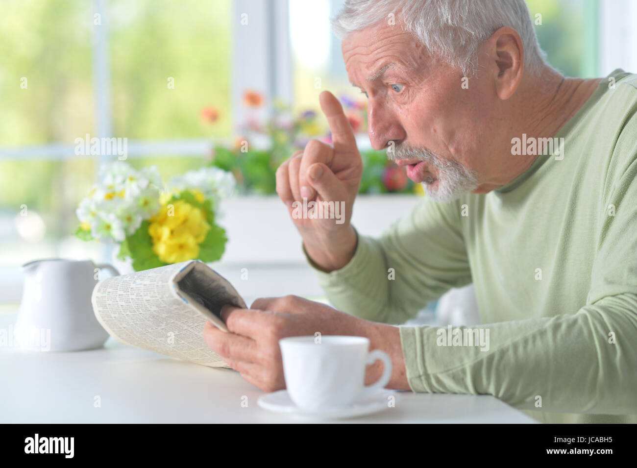 Beautiful old man reading a newspaper at a table Stock Photo - Alamy