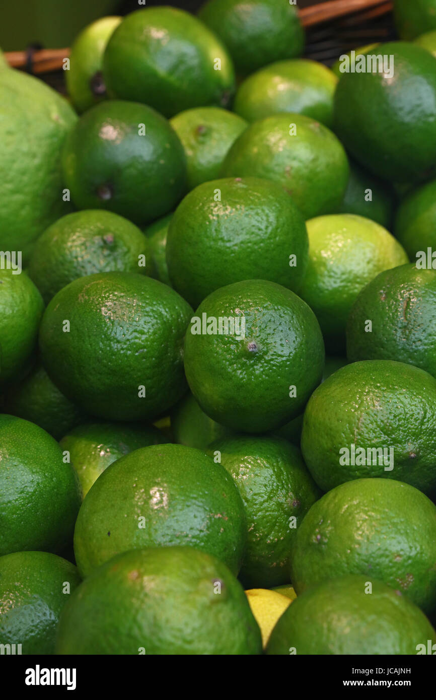 Heap of fresh green ripe lime fruits on retail market stall display ...
