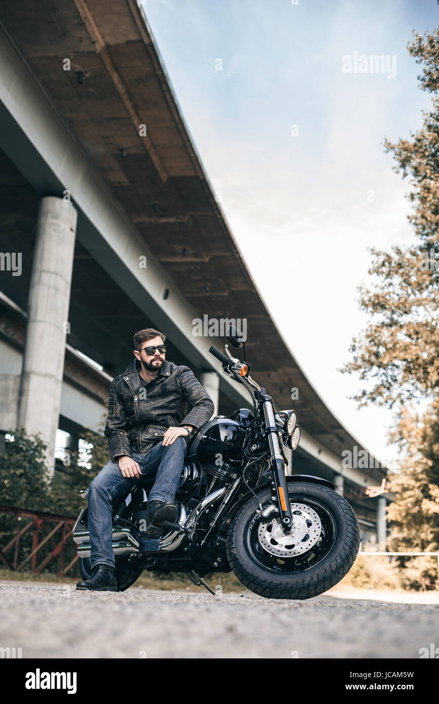 Man sat on motorcycle on the road during sunrise Stock Photo - Alamy