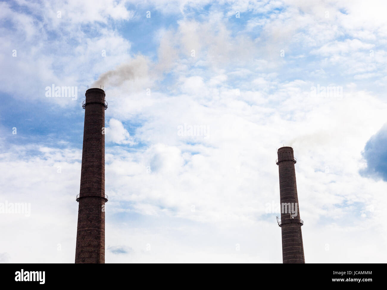 Two smoke stacks of the industrial plant against the cloudy sky Stock ...