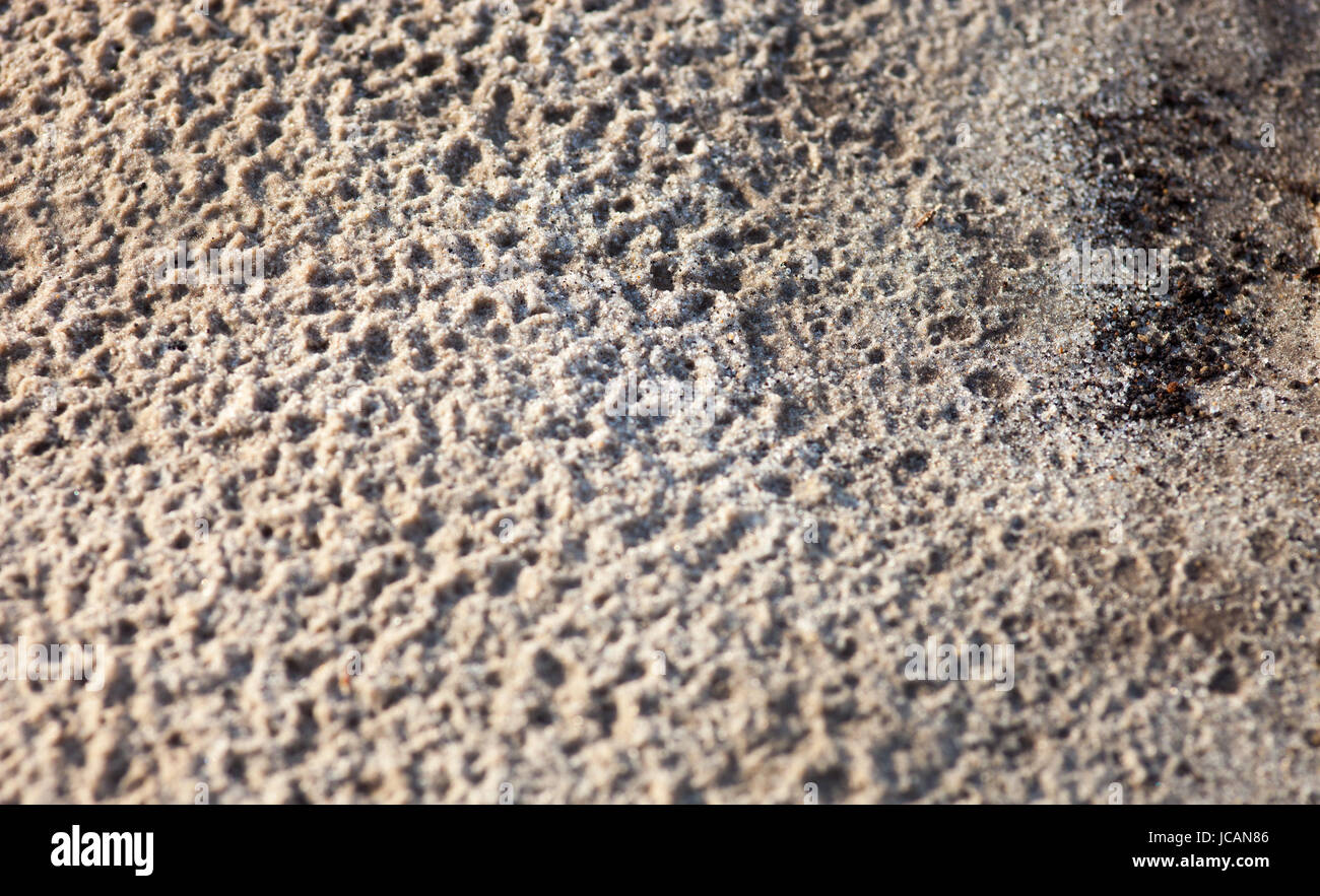 Sand surface after the rain with the visible traces of the raindrops ...