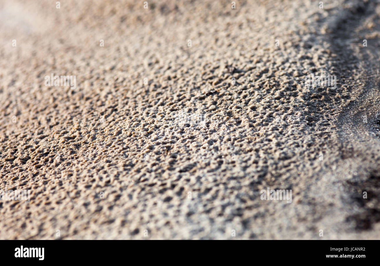 Sand surface after the rain with the visible traces of the raindrops ...