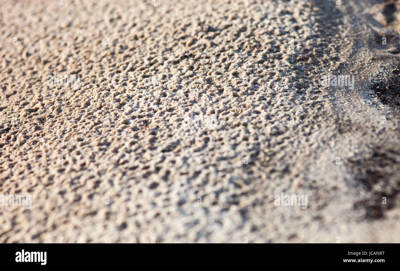 Sand surface after the rain with the visible traces of the raindrops ...