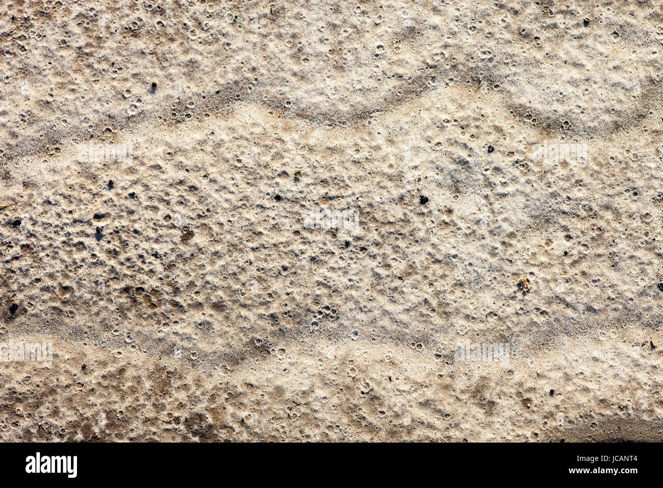 Sand surface after the rain with the visible traces of the raindrops ...