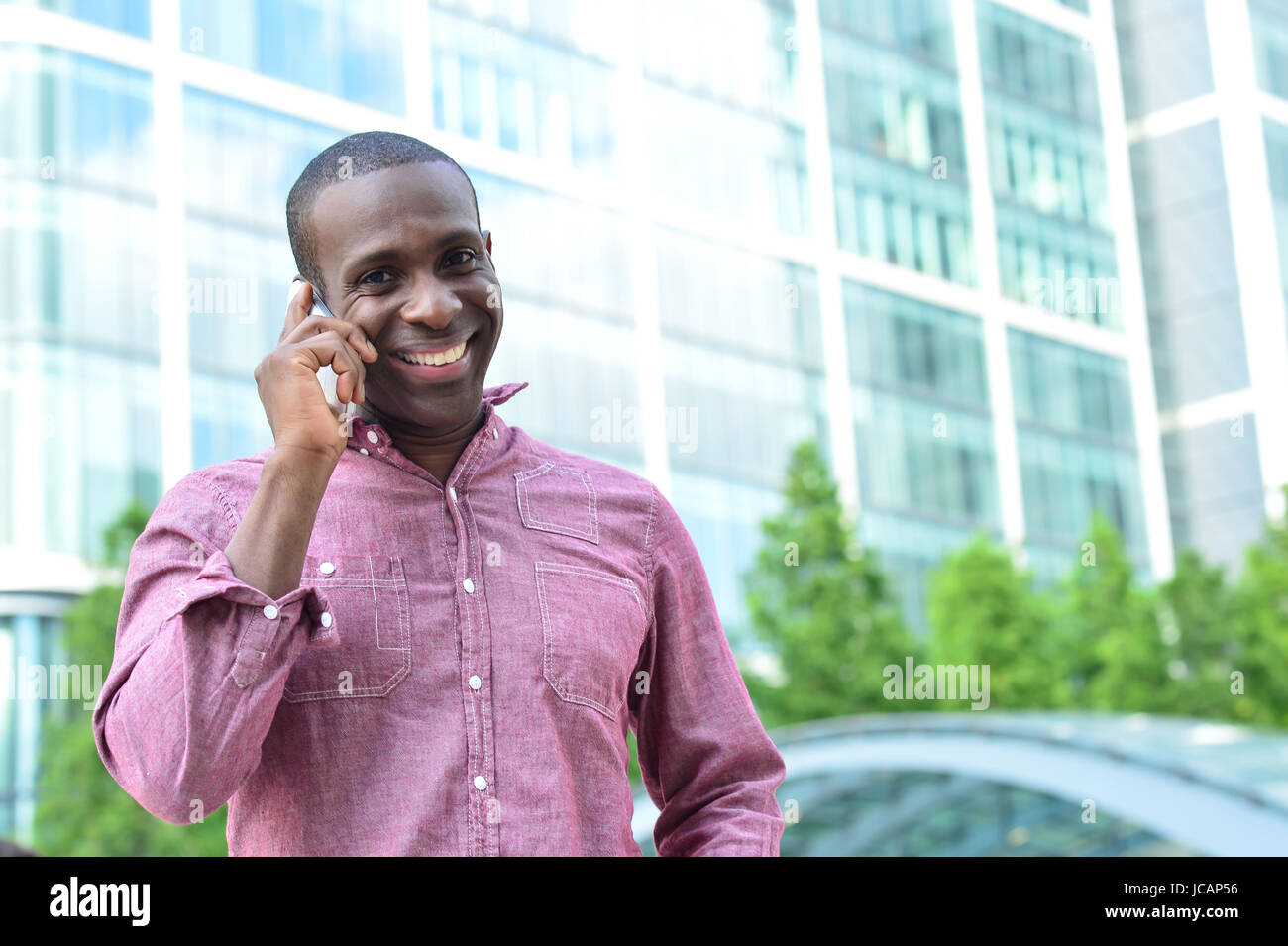 Smiling man communicating through cellphone Stock Photo - Alamy