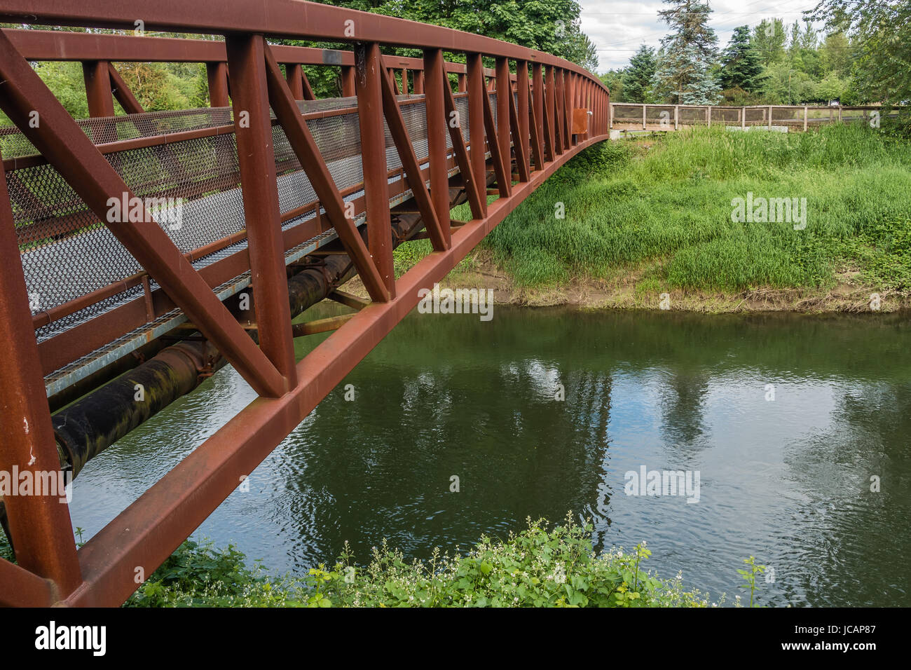 A rusted metal bridge spans the Green River in Kent, Washington Stock ...