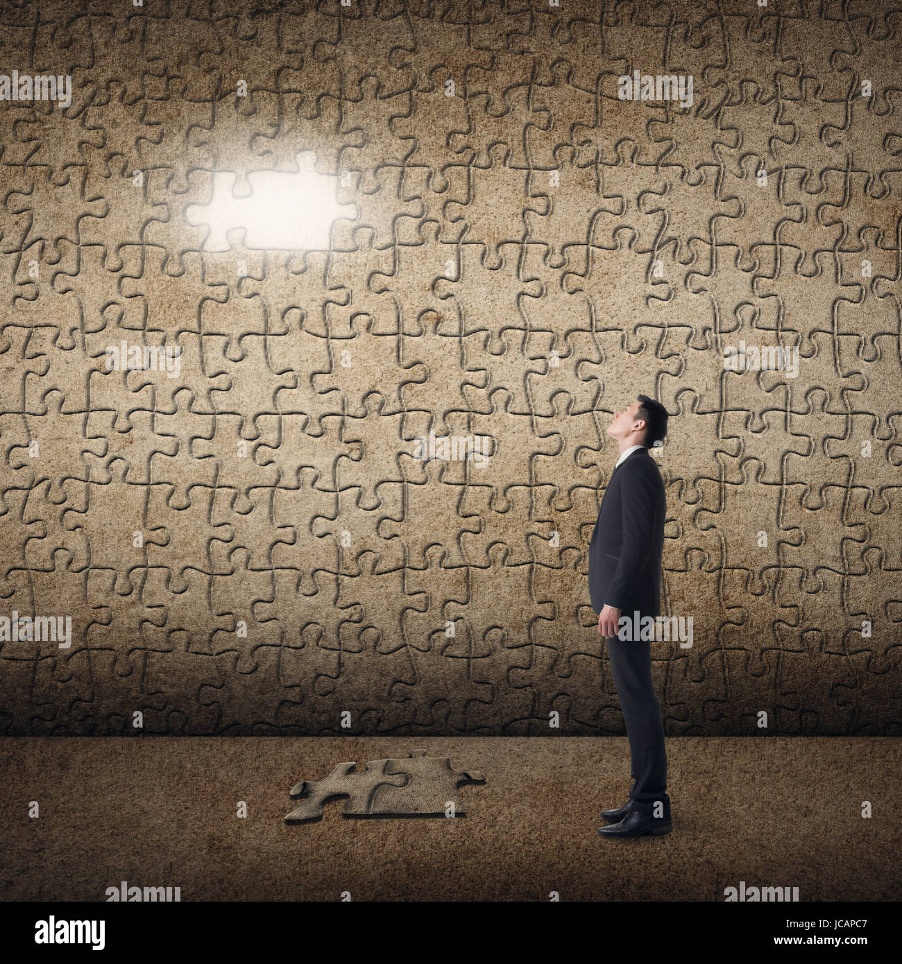Asian man standing in front of a puzzle wall. Concept of mystery ...