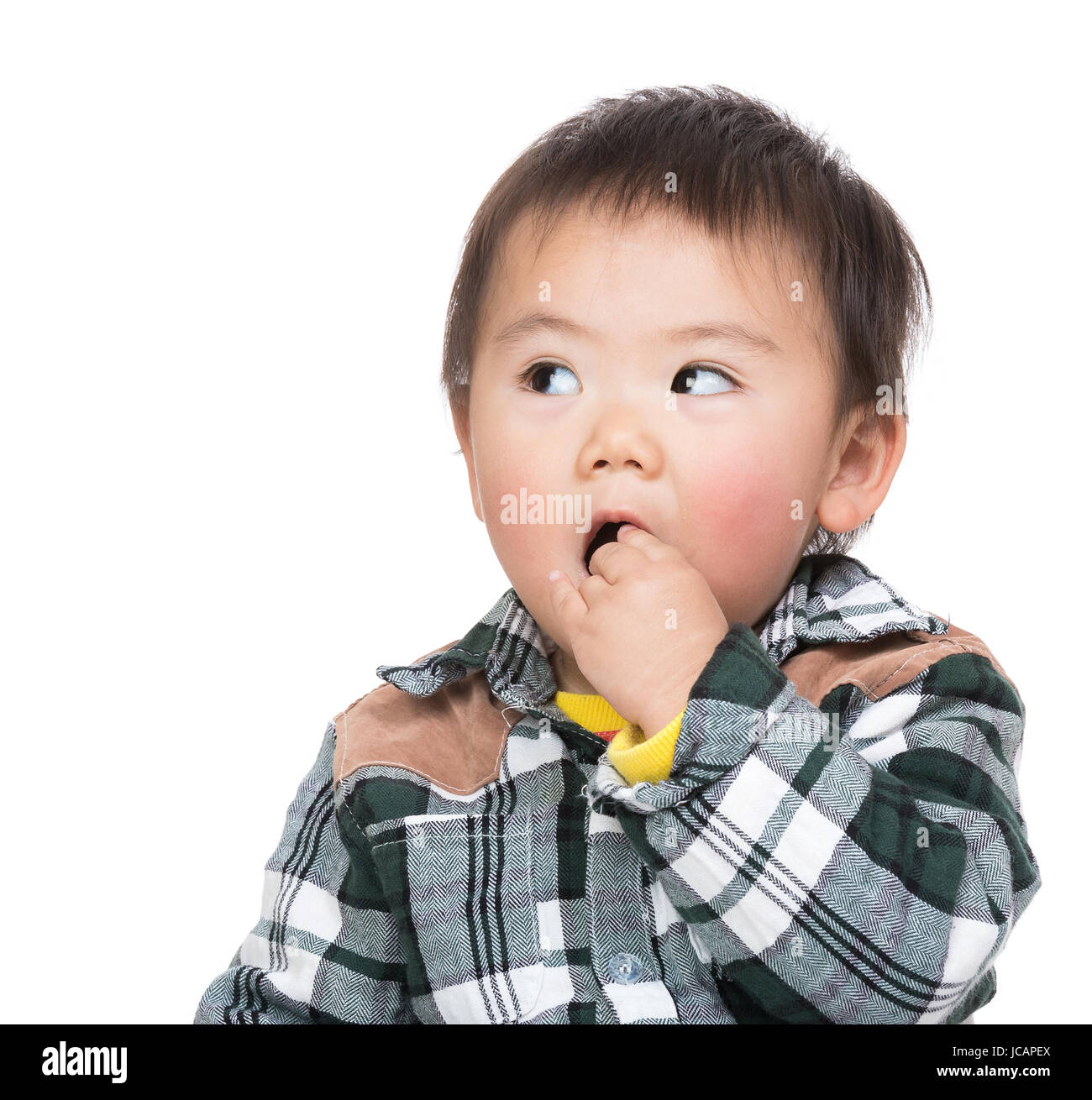 Little boy biting finger and looking aside Stock Photo - Alamy