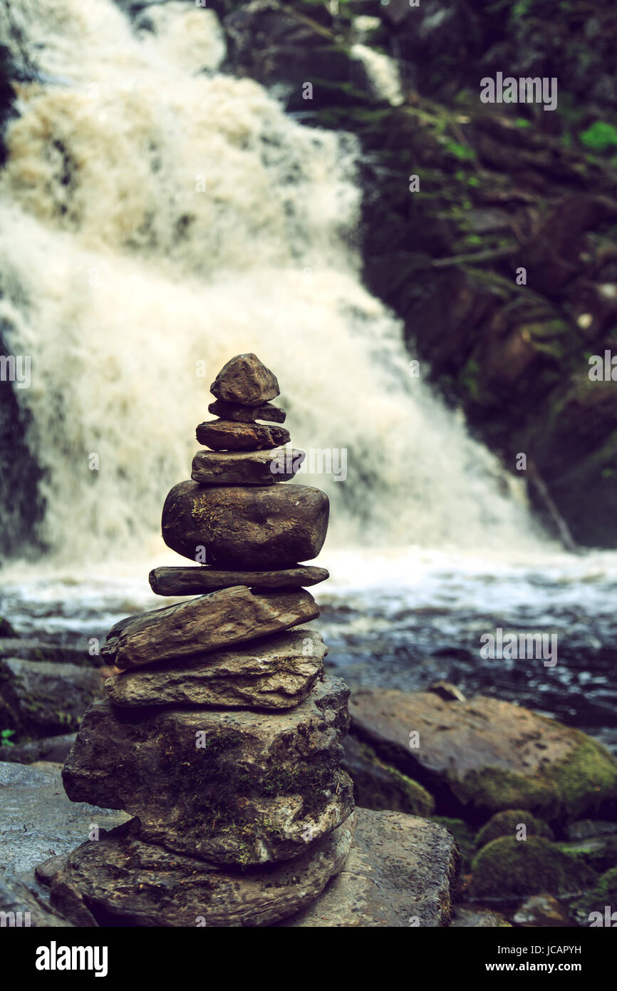 Stone pyramid near a tropical waterfall. The concept of harmony and ...