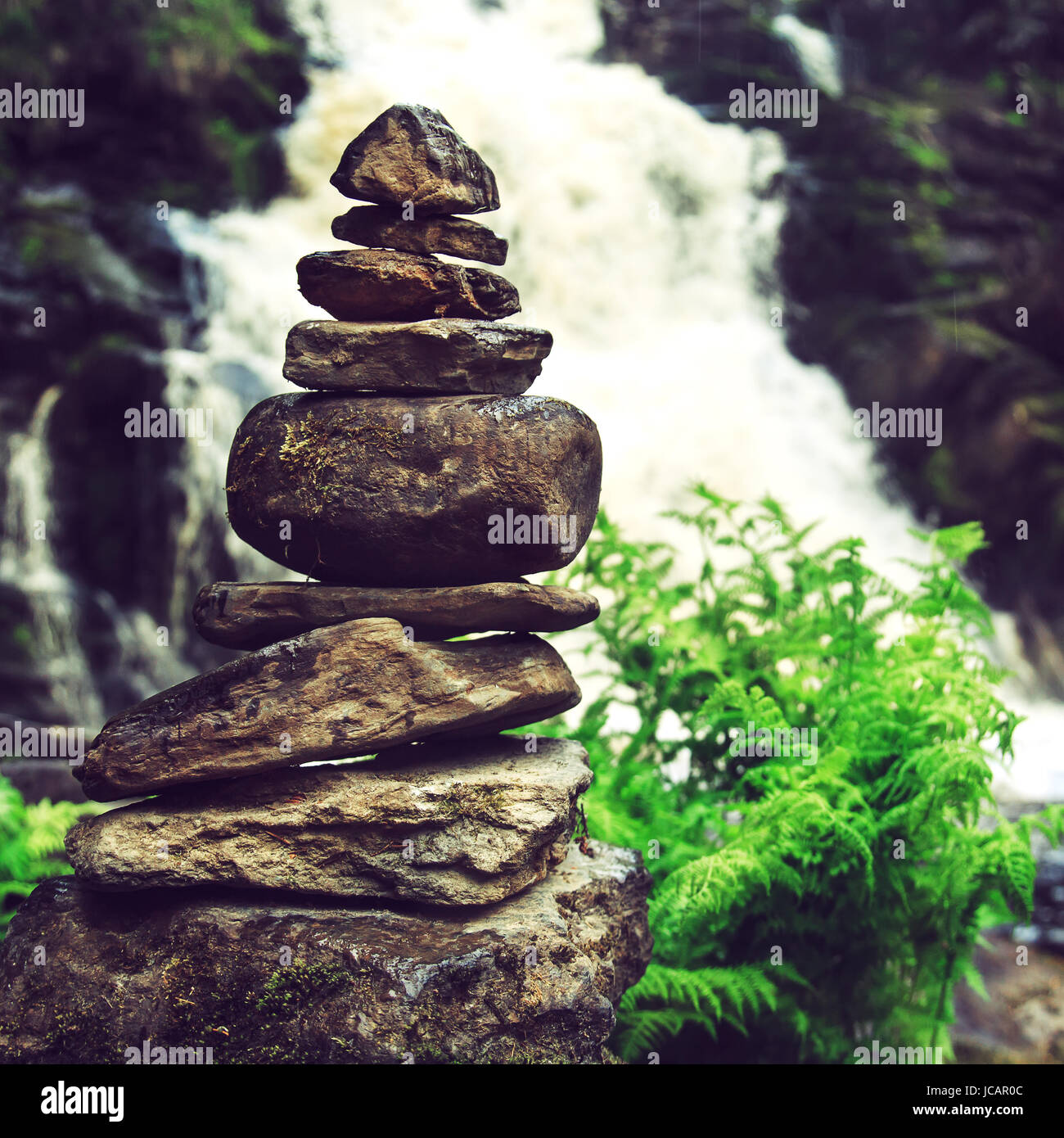 Stone pyramid near a tropical waterfall. The concept of harmony and ...
