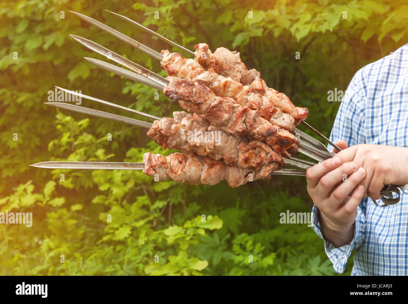 Delicious, juicy barbecue, roasted on a spit over an open fire. The ...