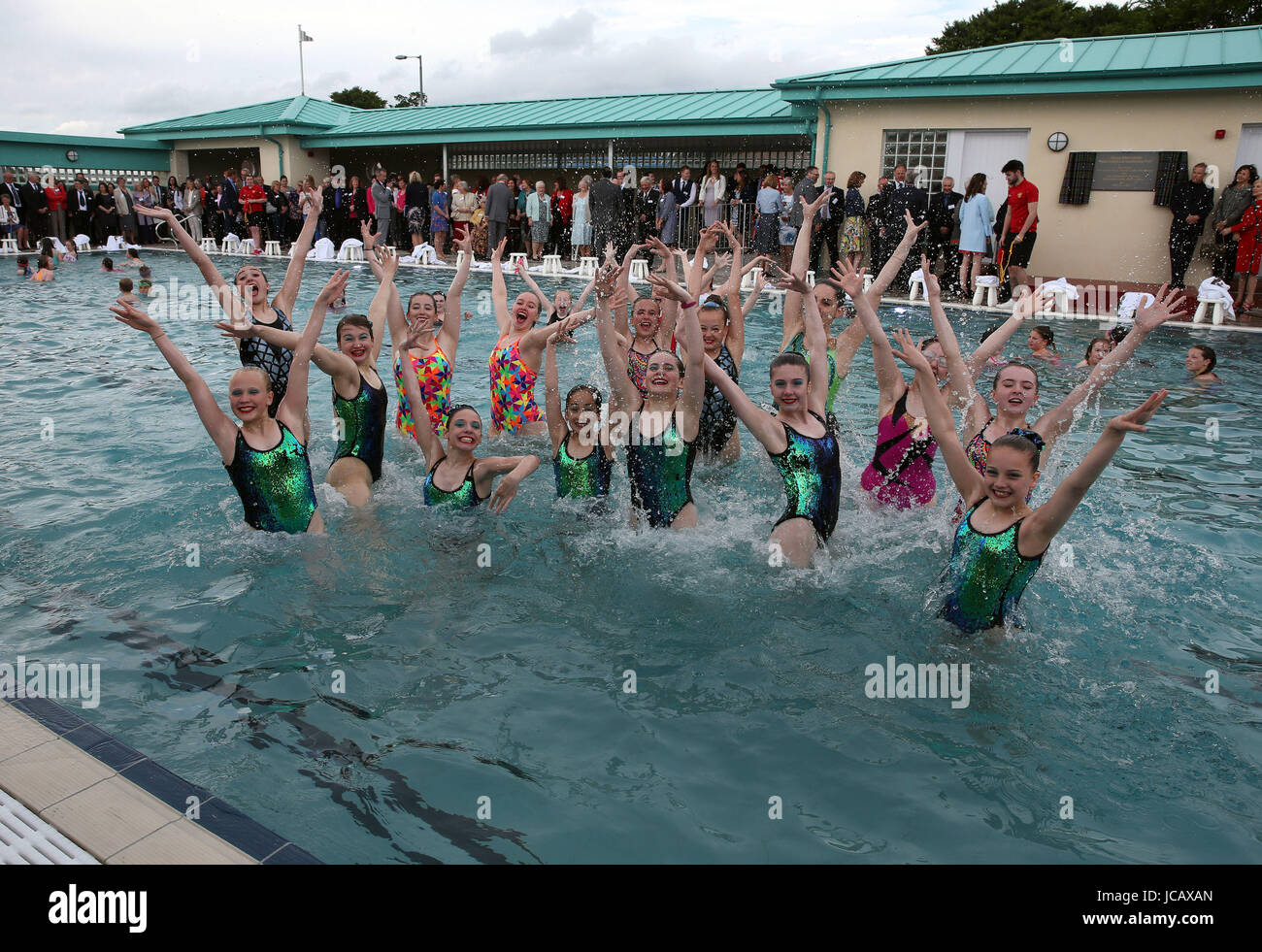 Swimmers perform a routine as The Prince of Wales, known as the Duke of ...