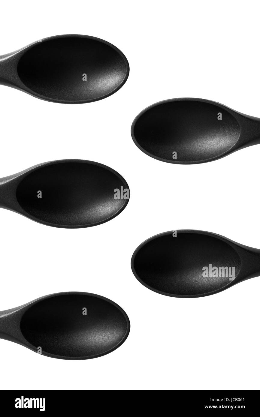 five black spoons on white background Stock Photo - Alamy