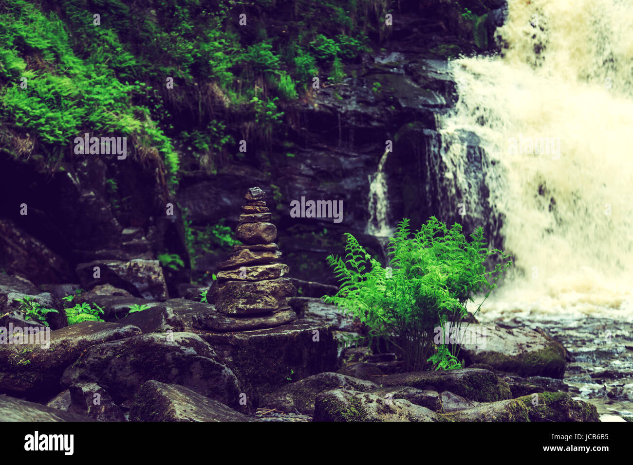 Stone pyramid near a tropical waterfall. The concept of harmony and ...