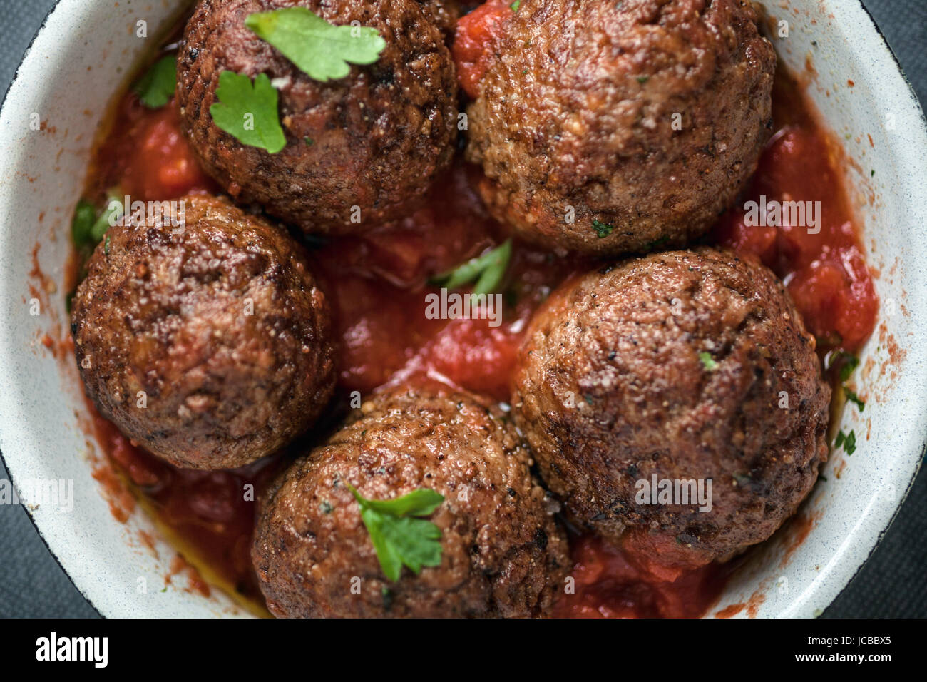 Serving of delicious seasoned meatballs in tomato sauce garnished with ...