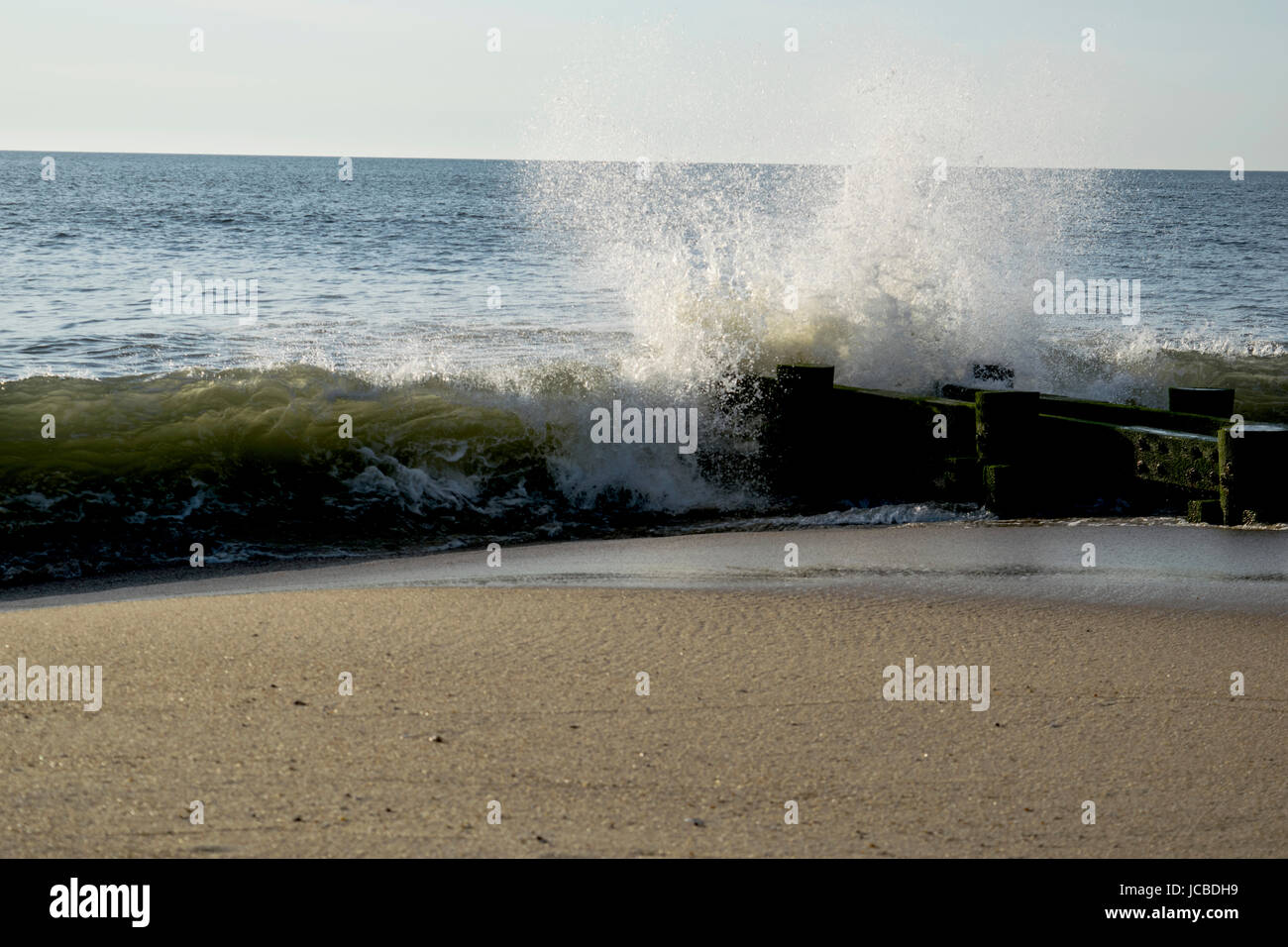waves crash against the shore and a jetty Stock Photo - Alamy