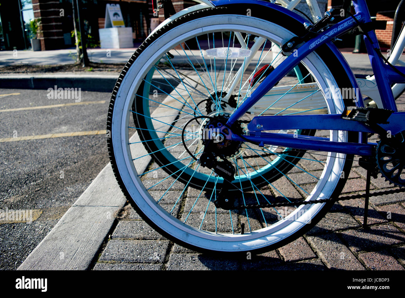 Back tires of two bikes parked on a brick sidewalk Stock Photo - Alamy