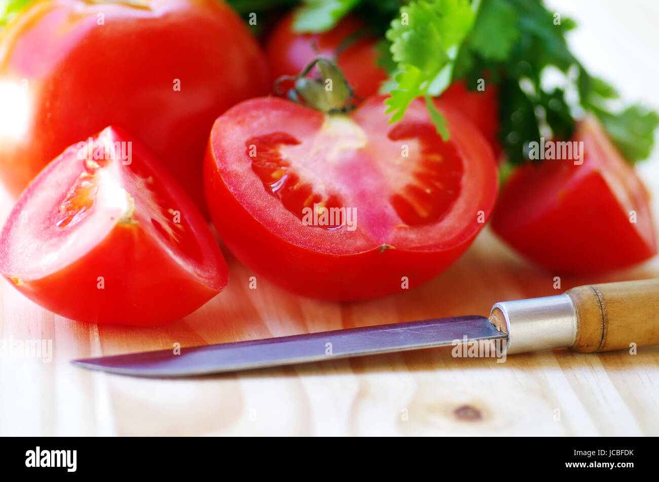 ripe tomato sliced and knife on table Stock Photo - Alamy