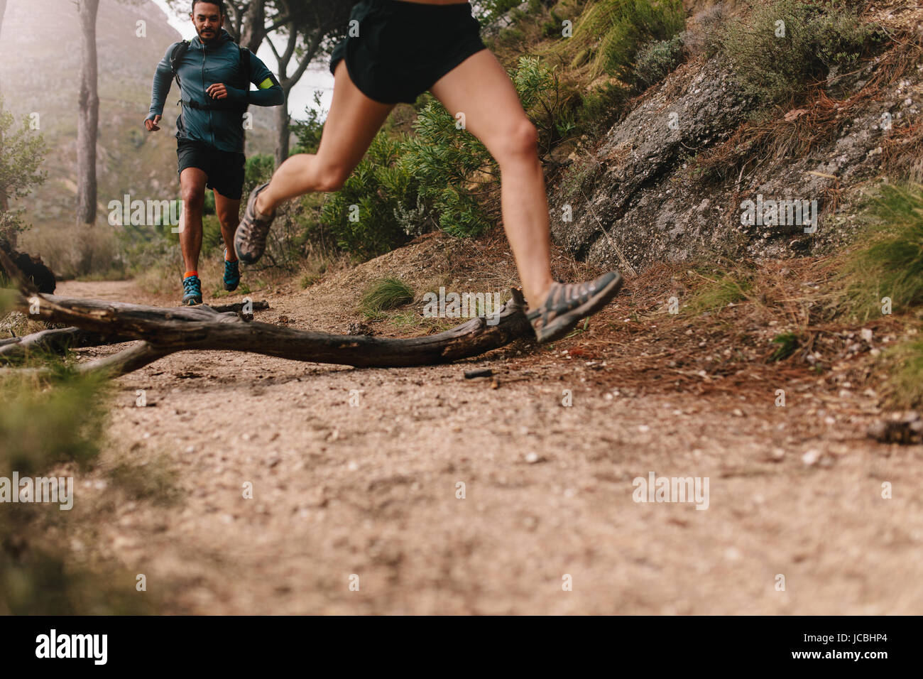 Young people running on country trail path. Low angle shot of runners ...