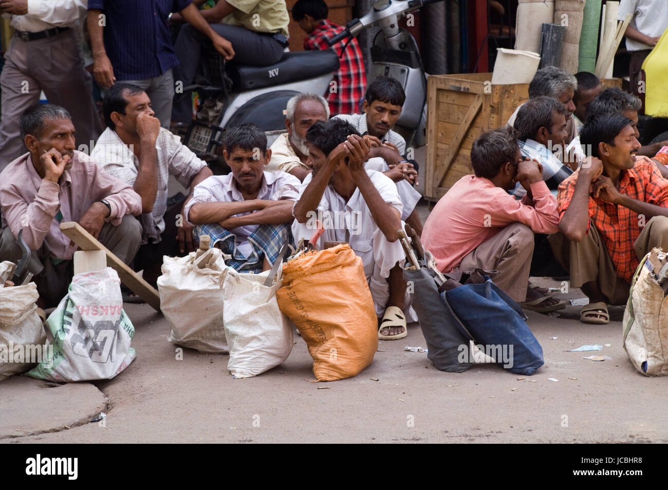 Group of tradesmen waiting on the street for work in Old Delhi, India ...