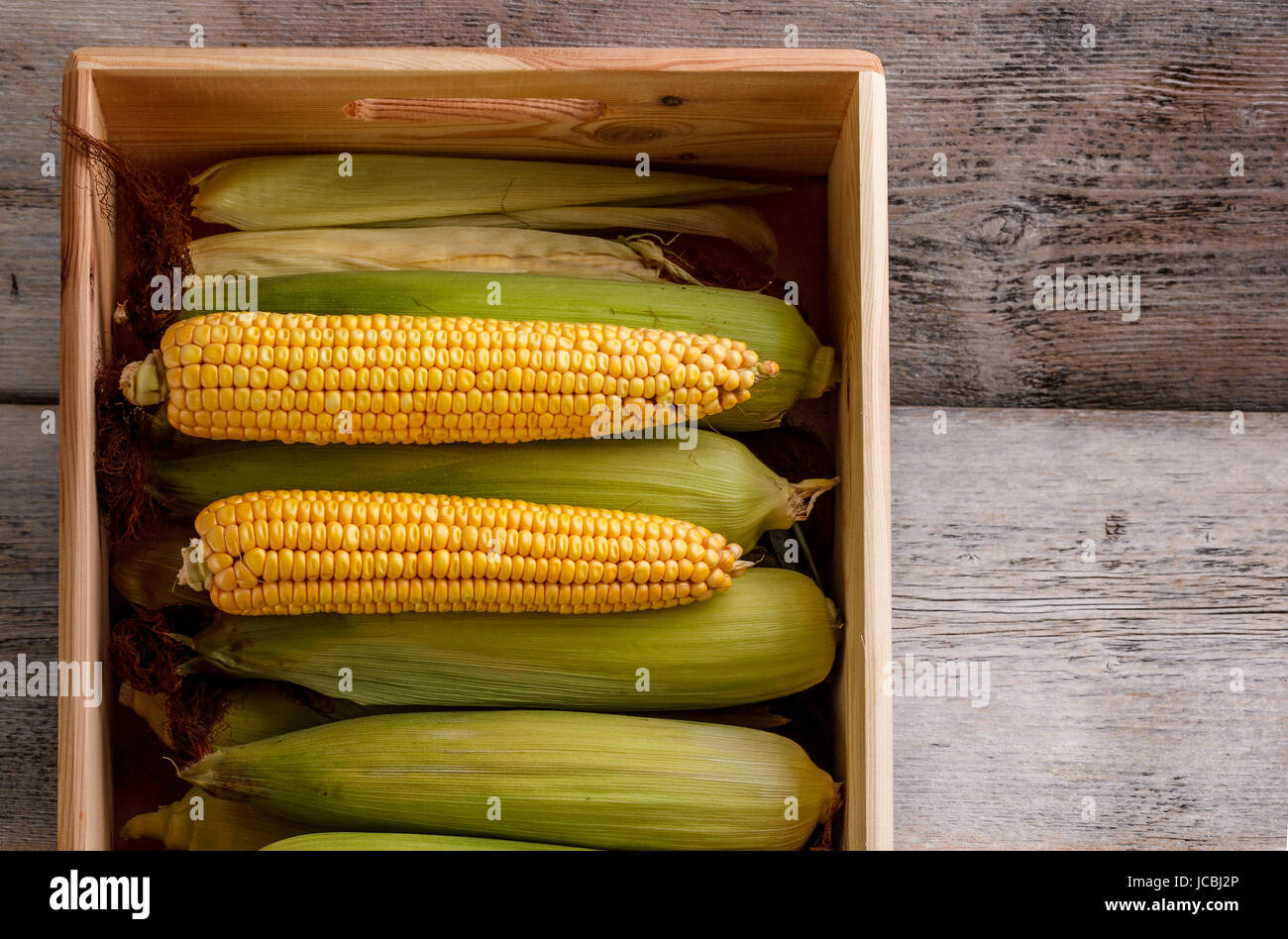 Fresh raw corn cobs in wooden crate Stock Photo - Alamy