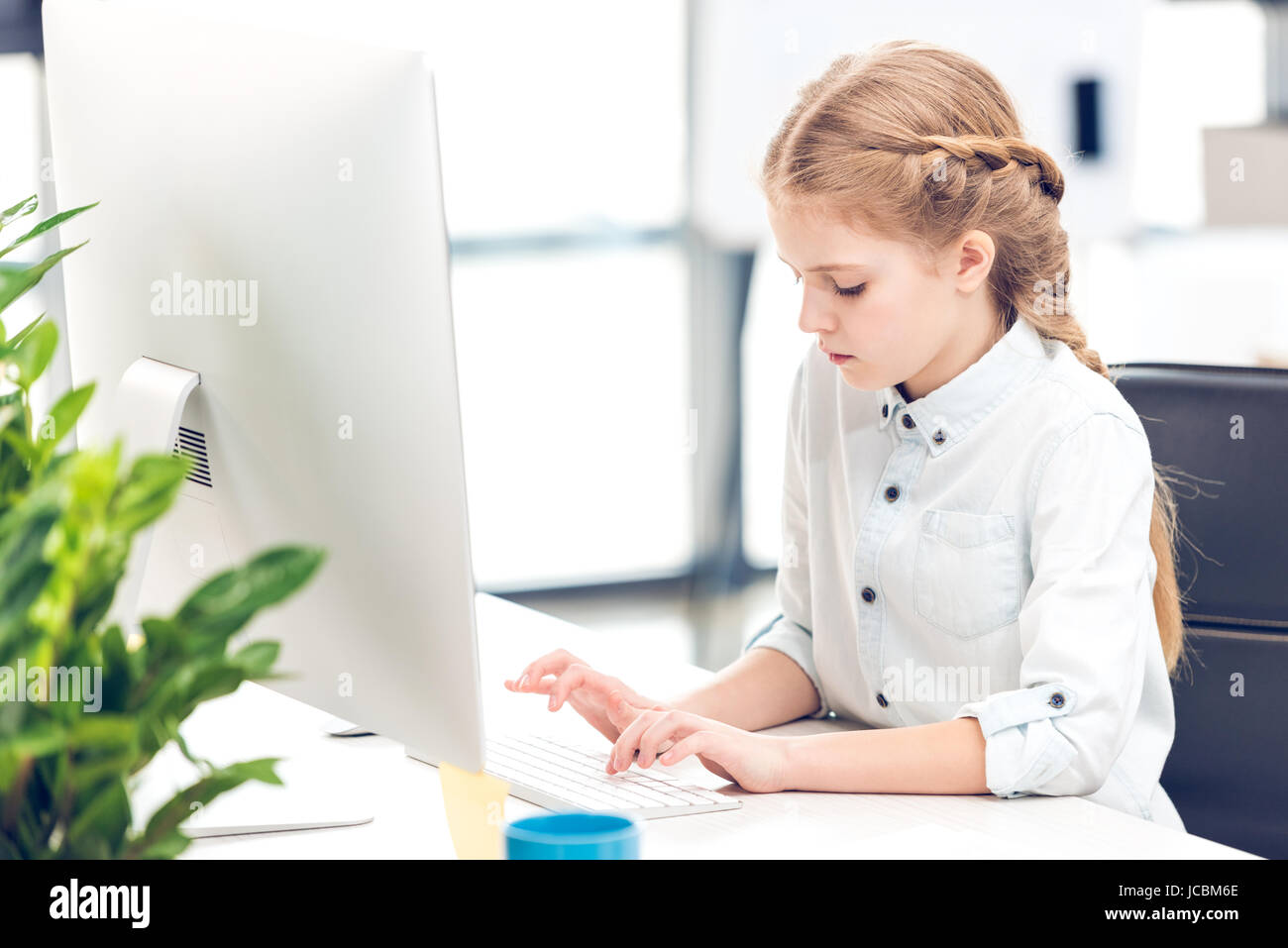 Little girl pretending to be businesswoman and working with computer in ...