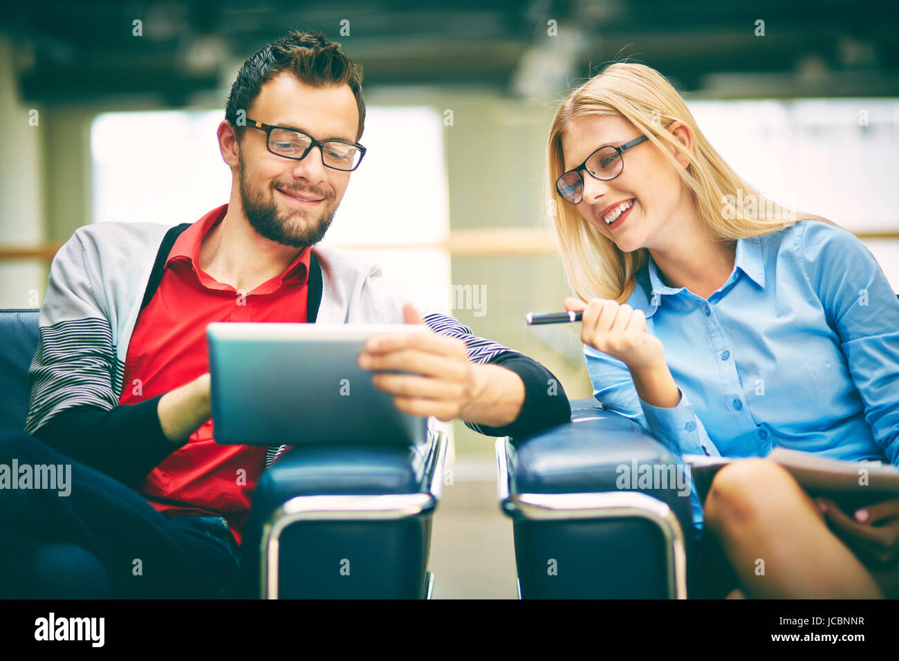 Two business partners discussing project in touchpad Stock Photo - Alamy
