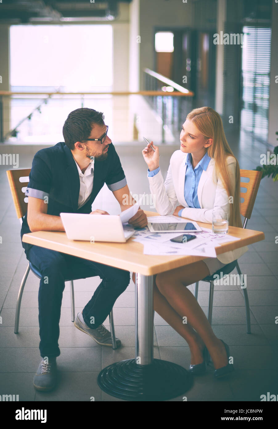 Two white collar workers planning work and discussing papers Stock Photo - Alamy