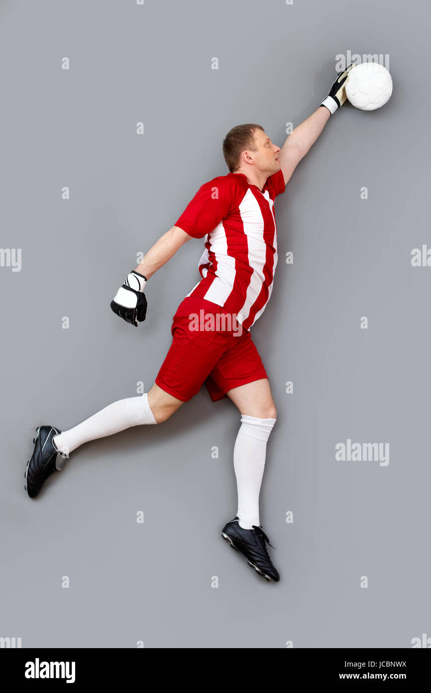 Goalkeeper catching the ball over grey background Stock Photo - Alamy