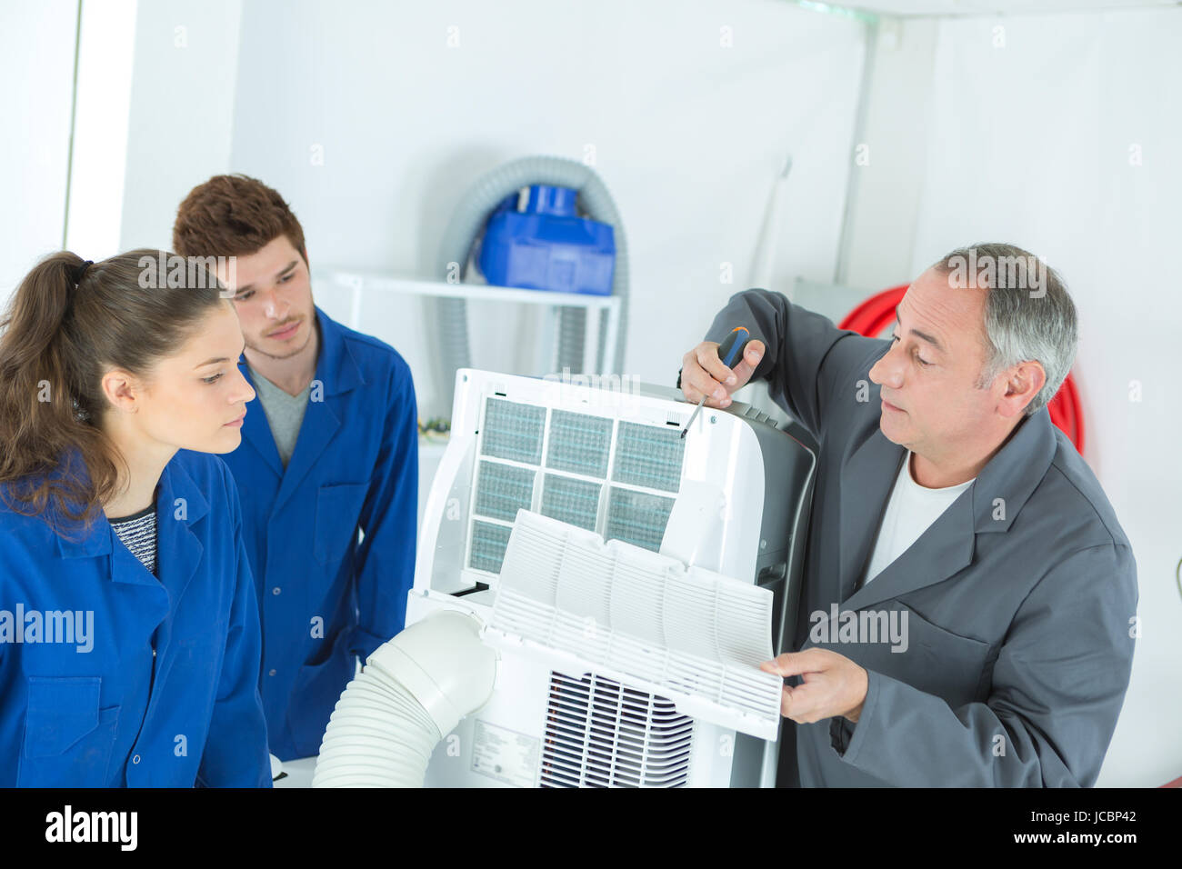 vocational students learns air conditioning repair from an experienced instructor Stock Photo ...