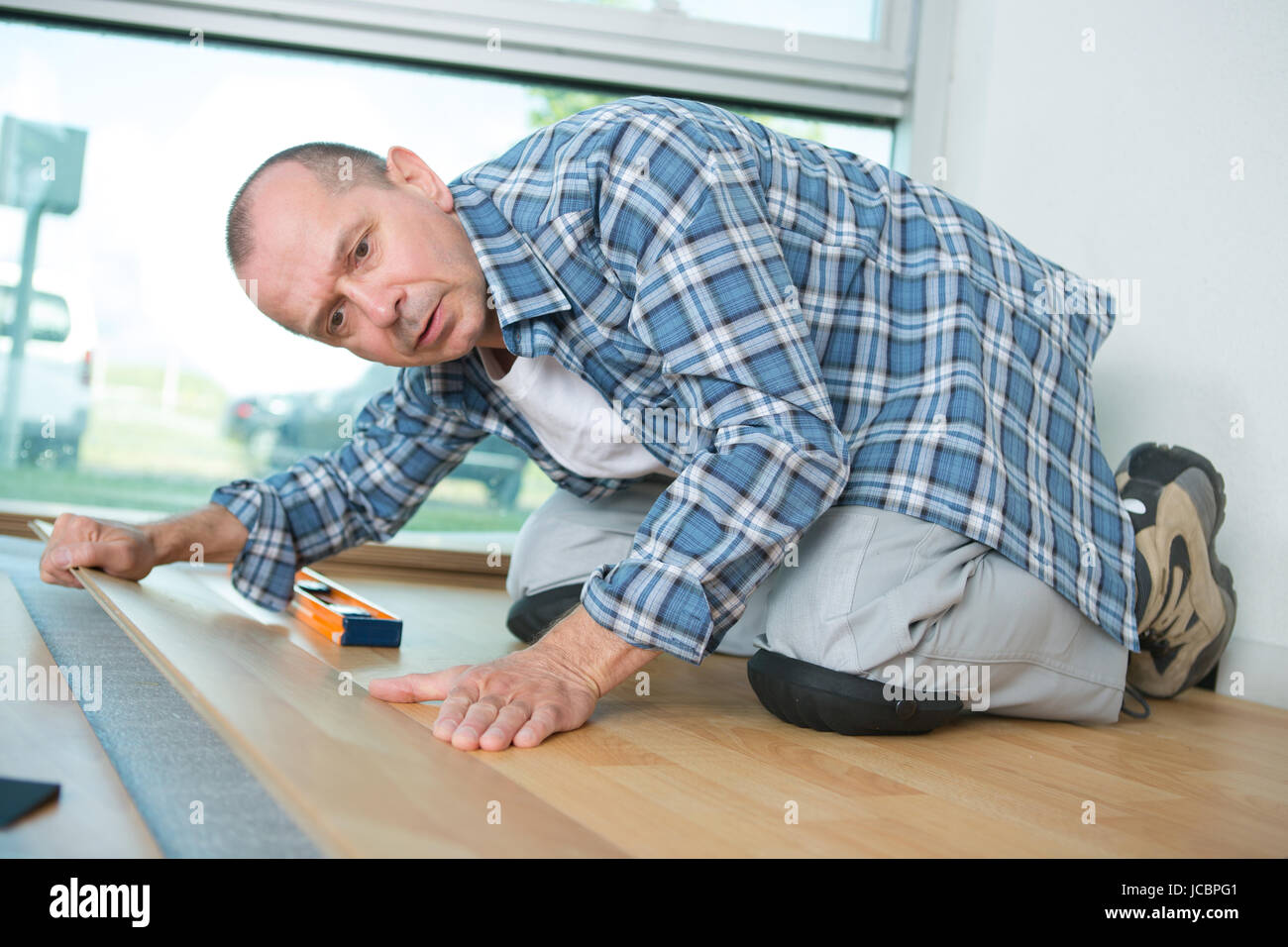 handyman installing wooden floor in new house Stock Photo - Alamy