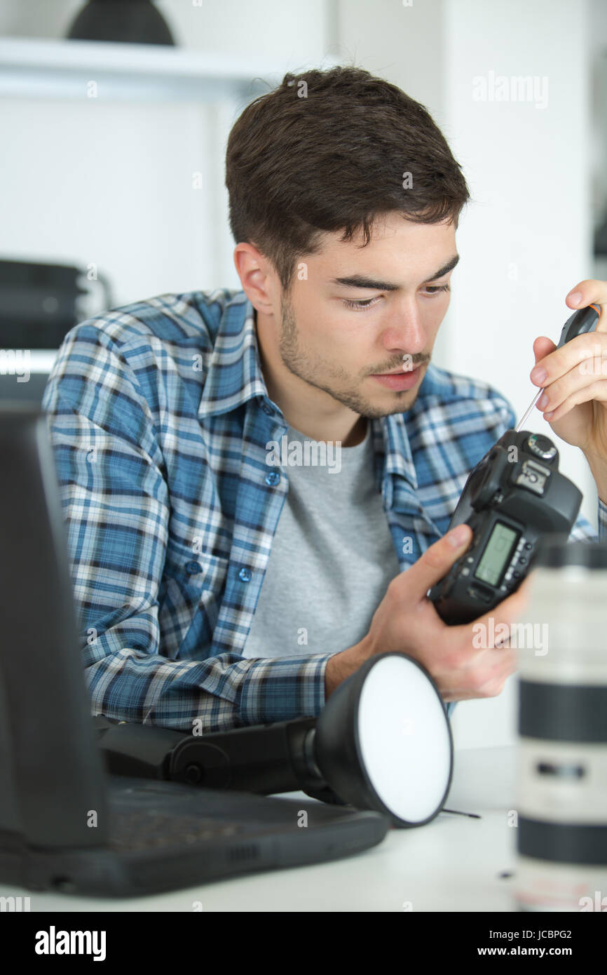 technician examining and repairing focus system on professional camera ...