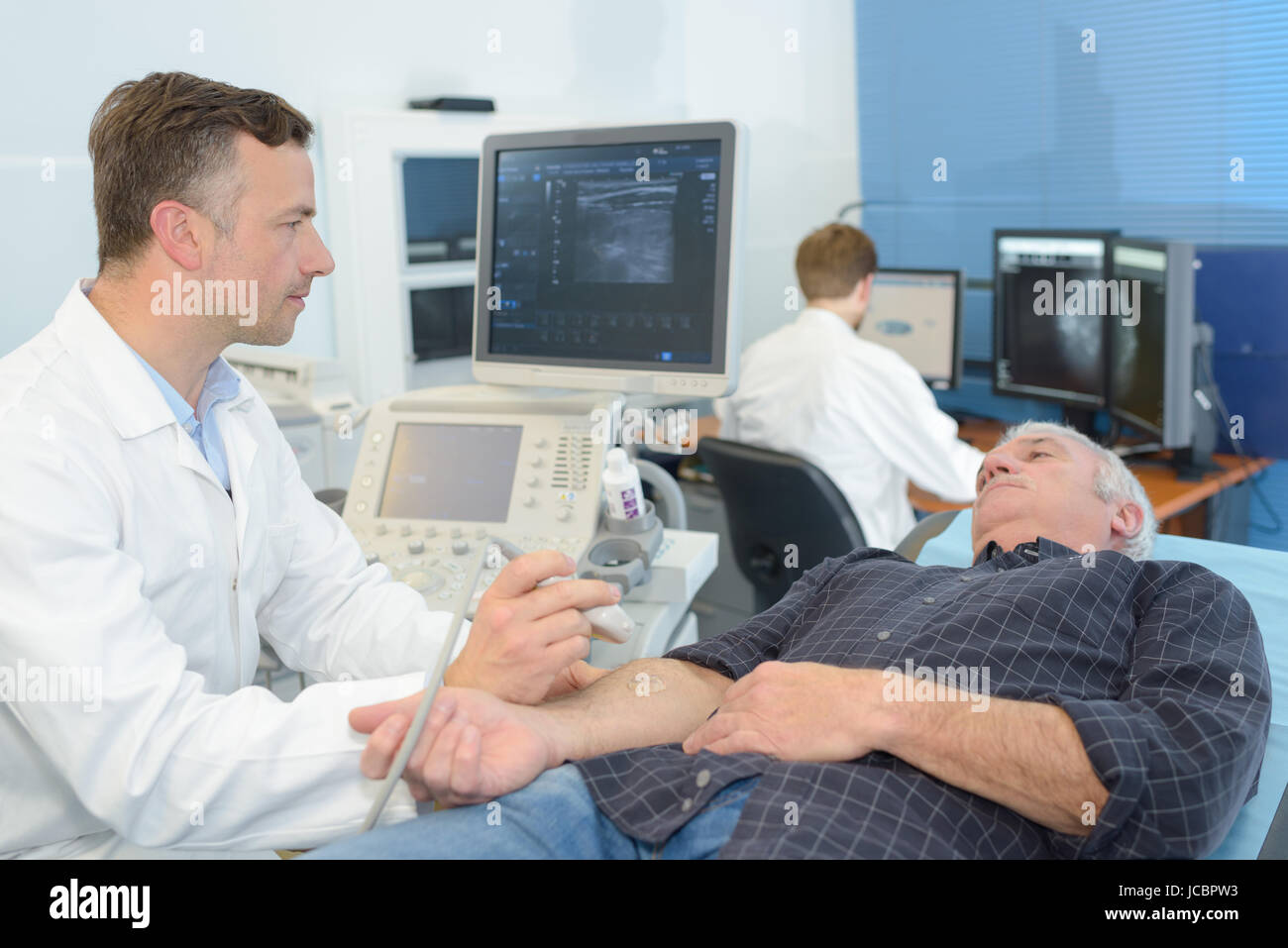 male doctor with male patient undergoing arm echography Stock Photo - Alamy