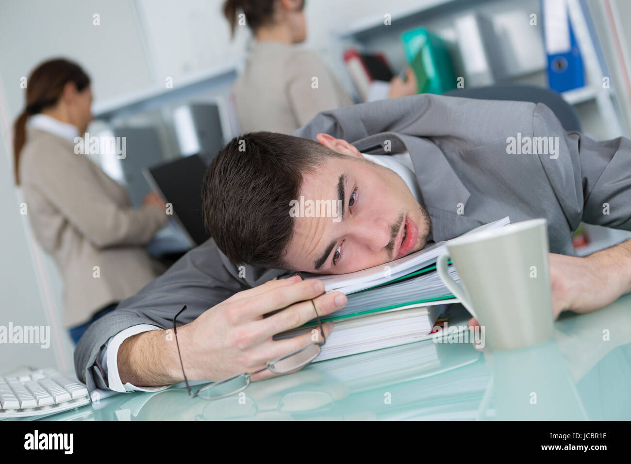 man sleeping on a desk Stock Photo - Alamy