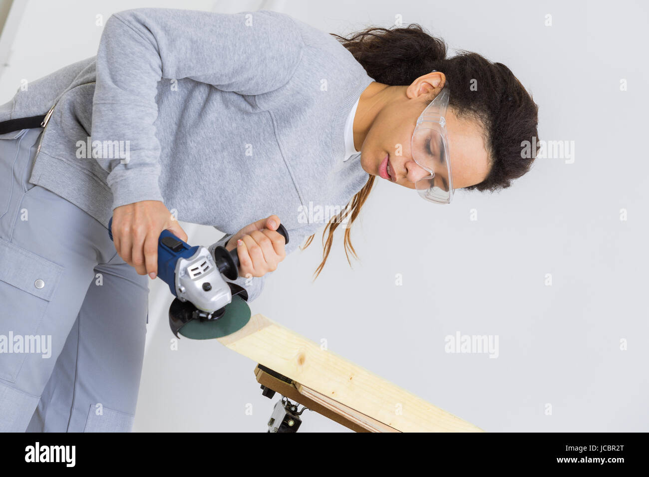 young female woodworker grinding wood in workshop Stock Photo - Alamy