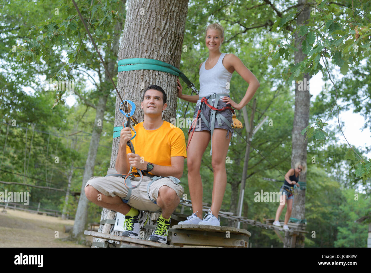 young couple having fun climbing in the trees Stock Photo - Alamy