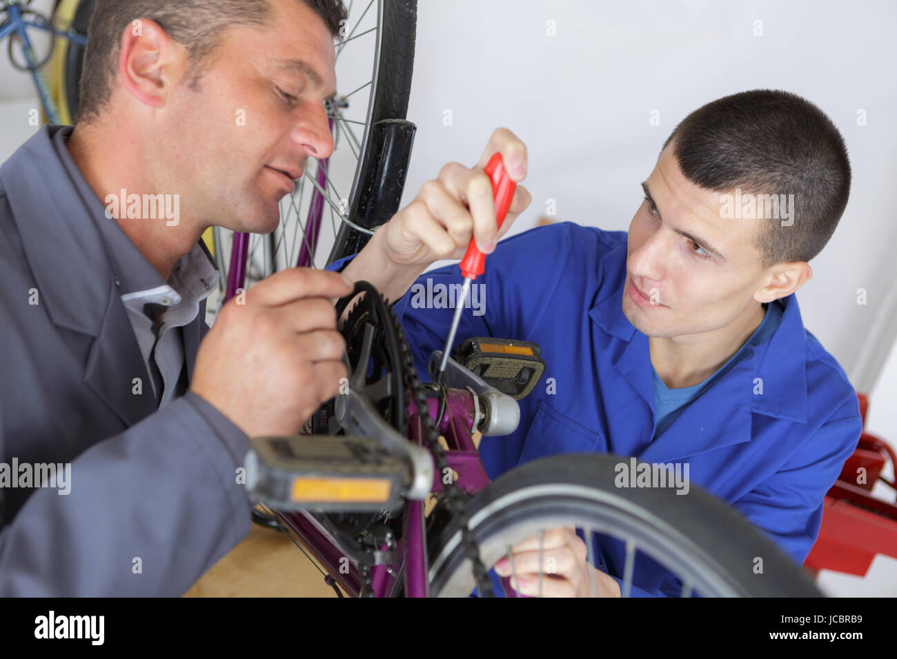 Mechanic repairman assembling bicycle hi-res stock photography and ...